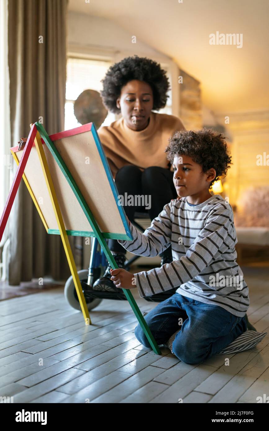 Happy child doing math exercises with her mother ot teacher together ...