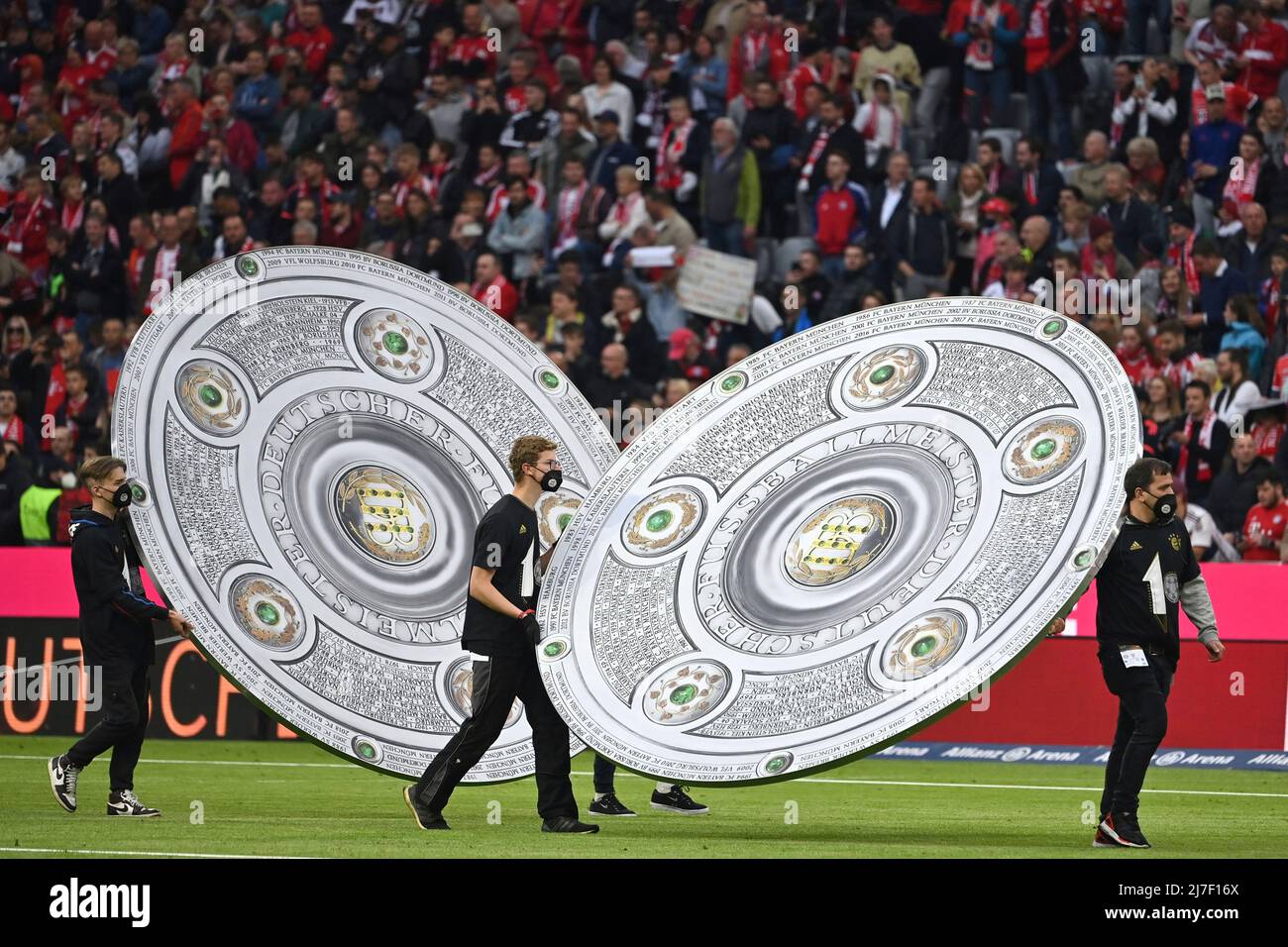 Helpers carry large dummies of the bowl, championship bowl, cup, trophy ...