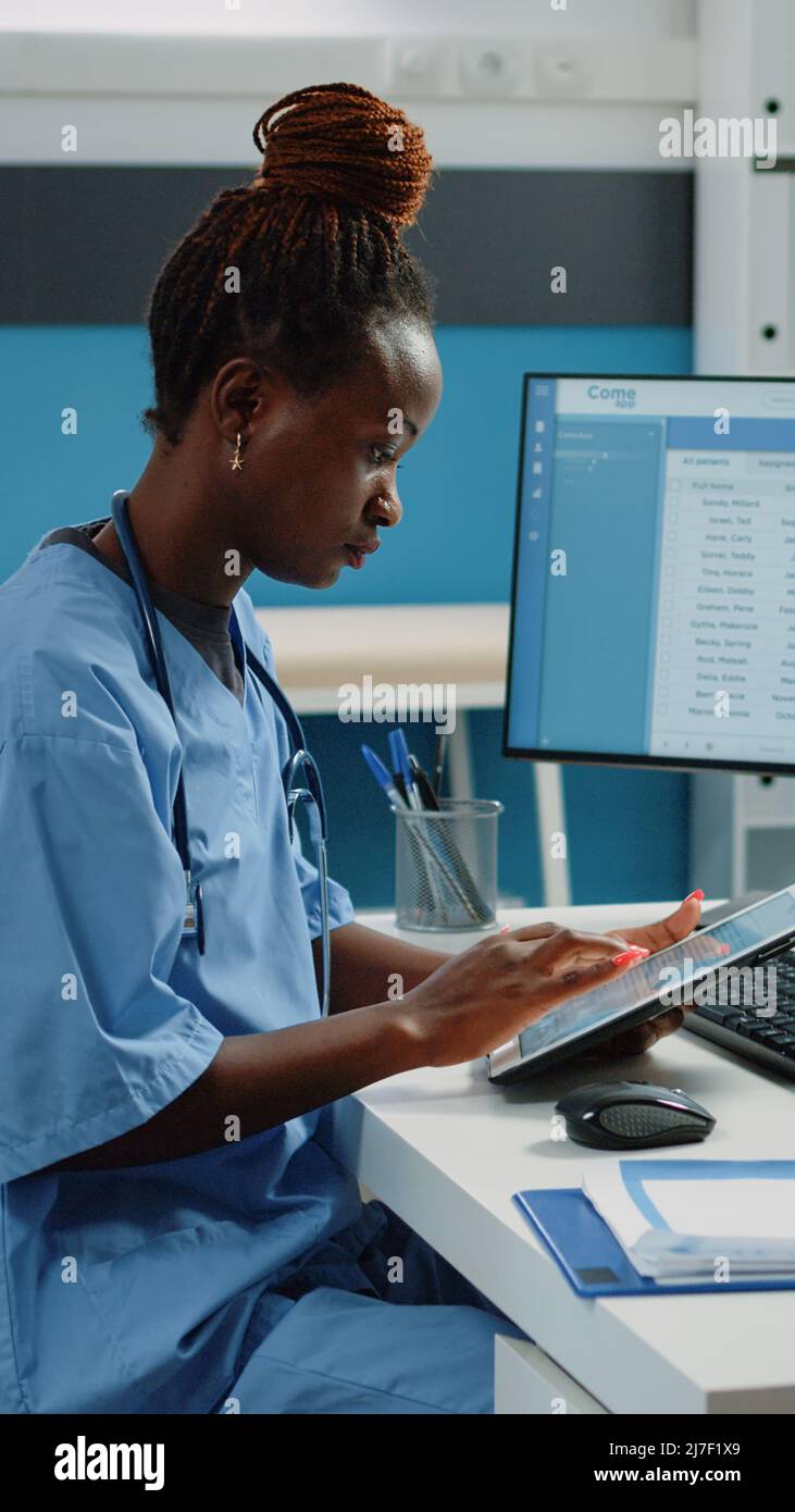 African american nurse using digital tablet for treatment. Black ...