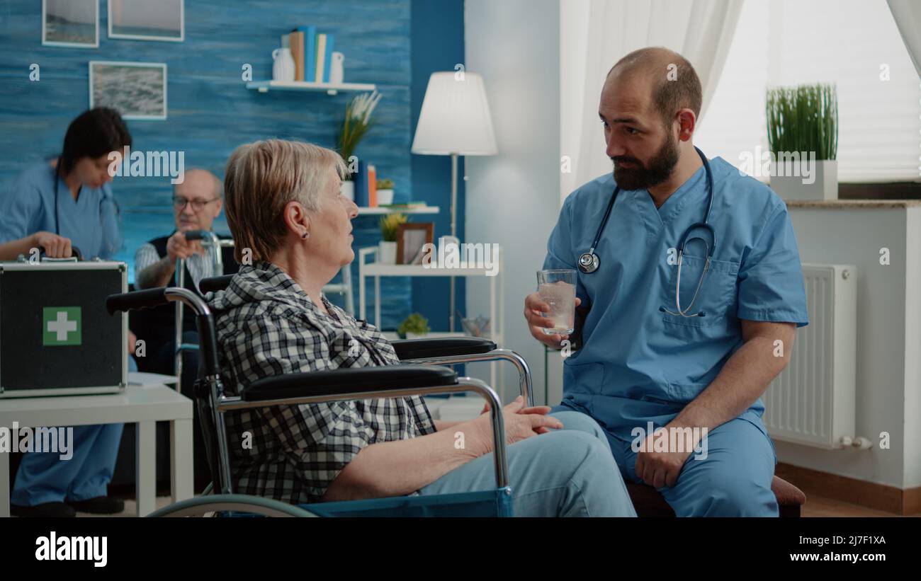 Nurse preparing effervescent pill in water glass for patient in nursing ...