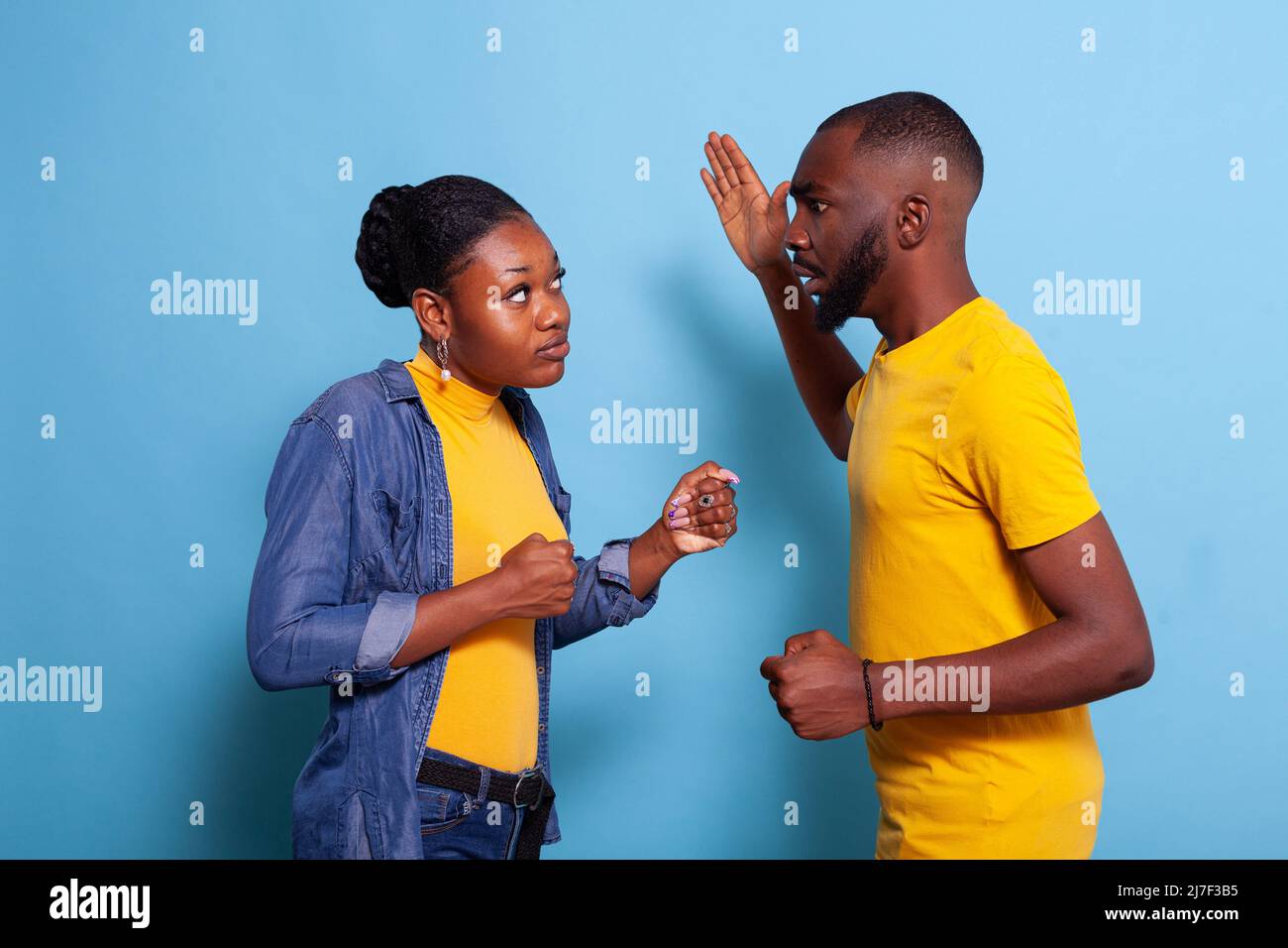 Frustrated man raising hand at girlfriend and arguing. Couple in ...