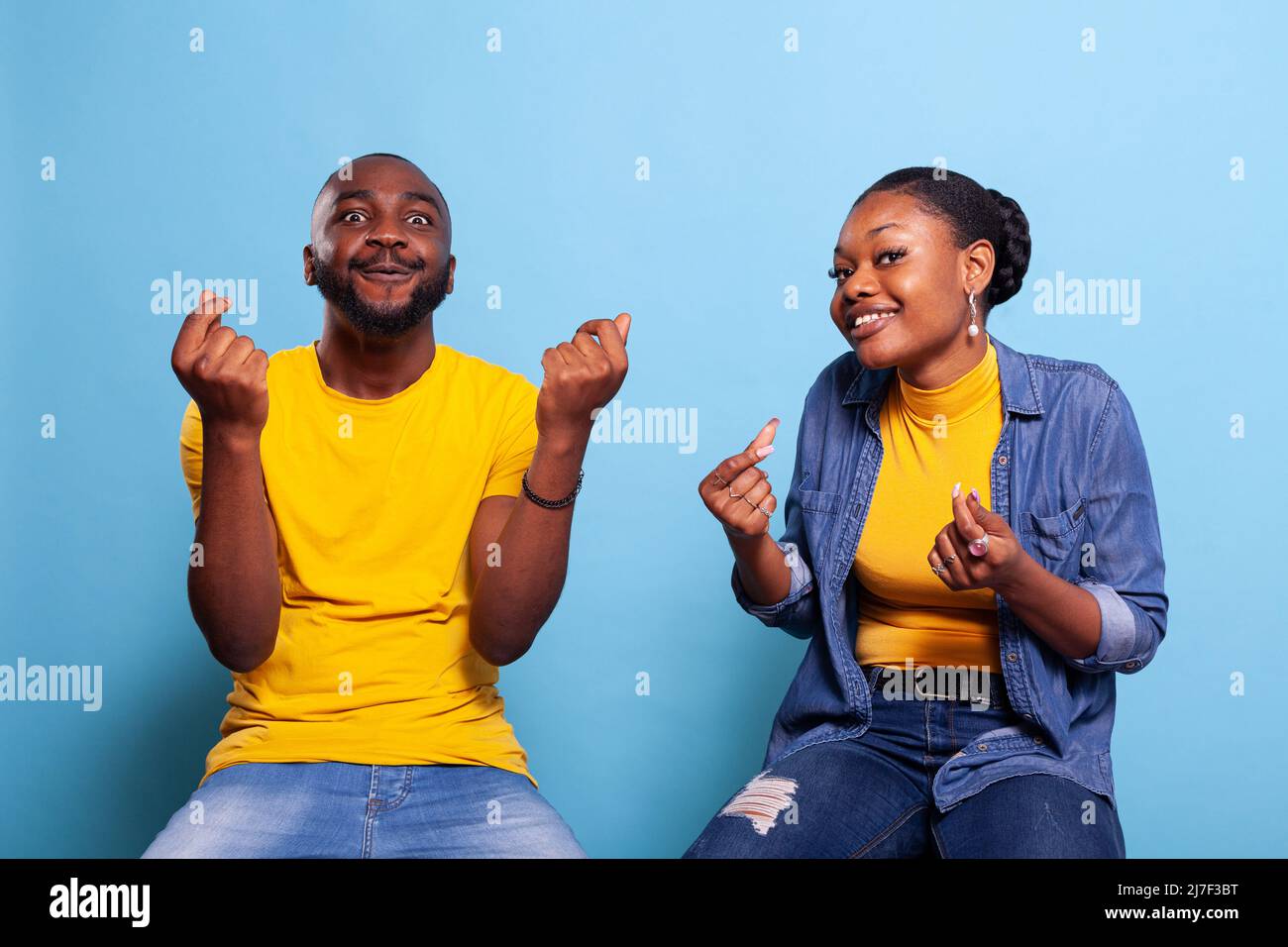 Couple doing money gesture and demanding cash reward while they sit in ...