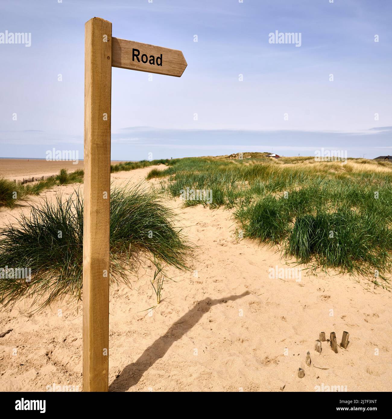 Wooden direction post pointing to the road Stock Photo - Alamy