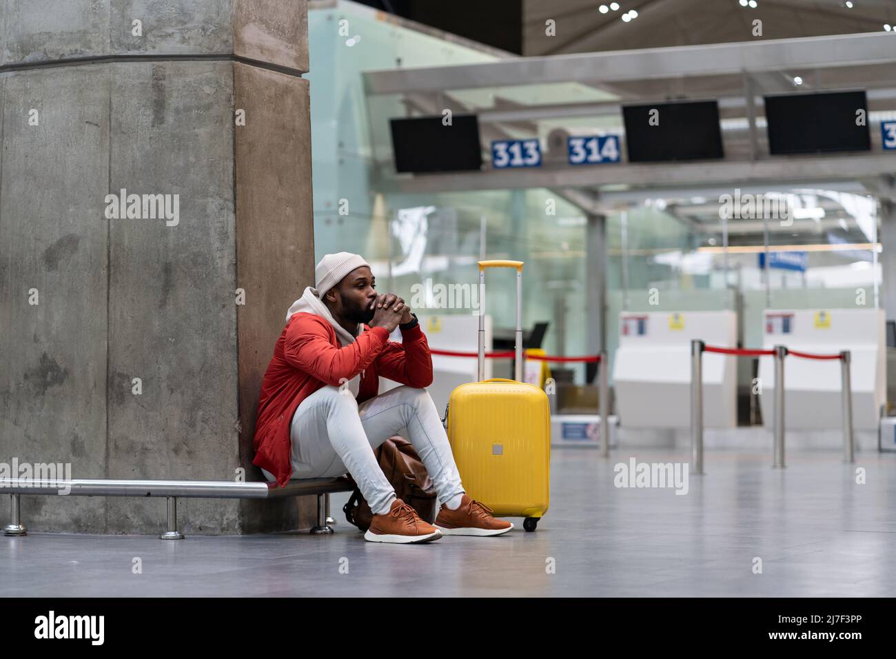 Exhausted African man on a long night connection at airport, waiting ...