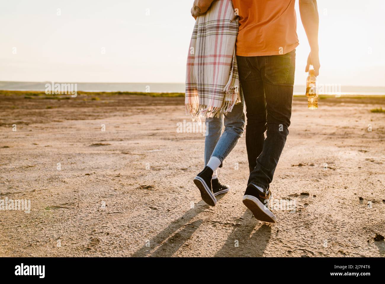 Young multiracial couple hugging while walking together during picnic ...