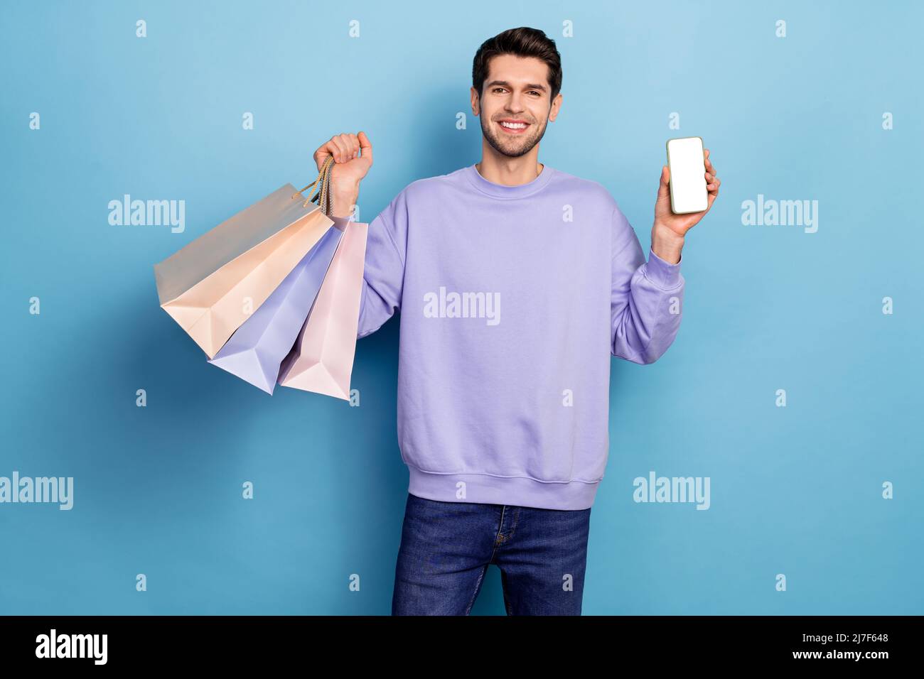 Portrait of attractive cheerful guy using device buying goods ...