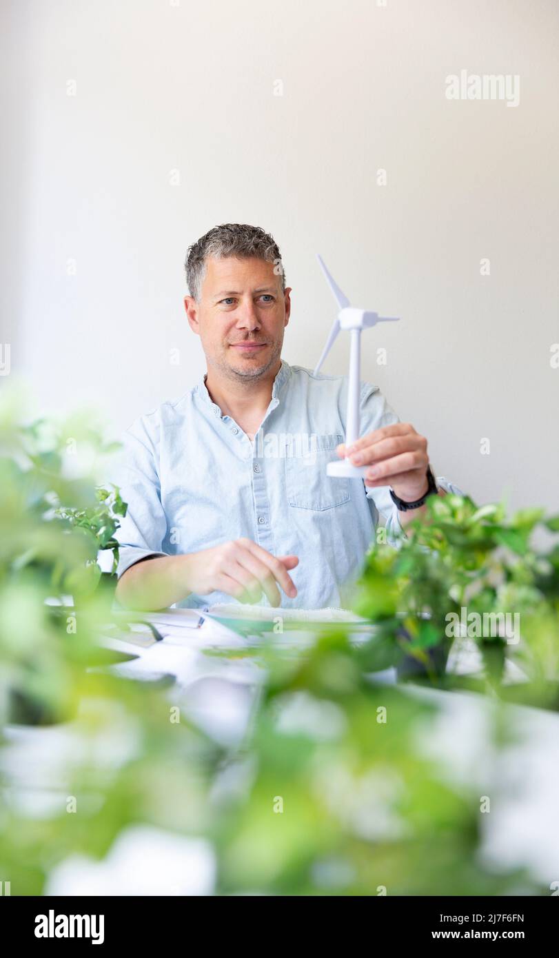 Business portrait of environmental engineer sitting at his work table ...