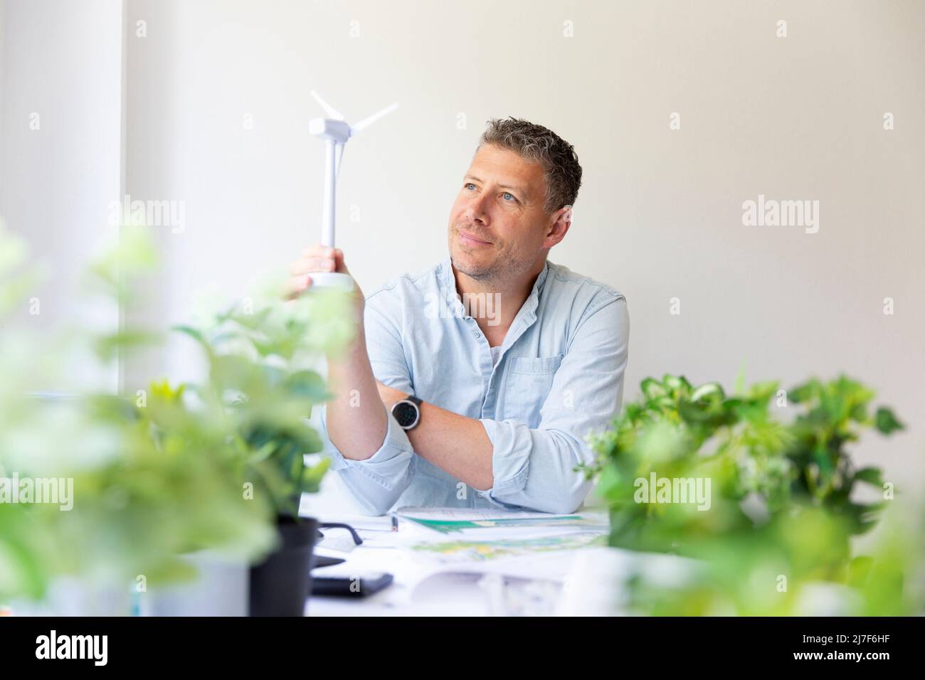 Business portrait of environmental engineer sitting at his work table ...