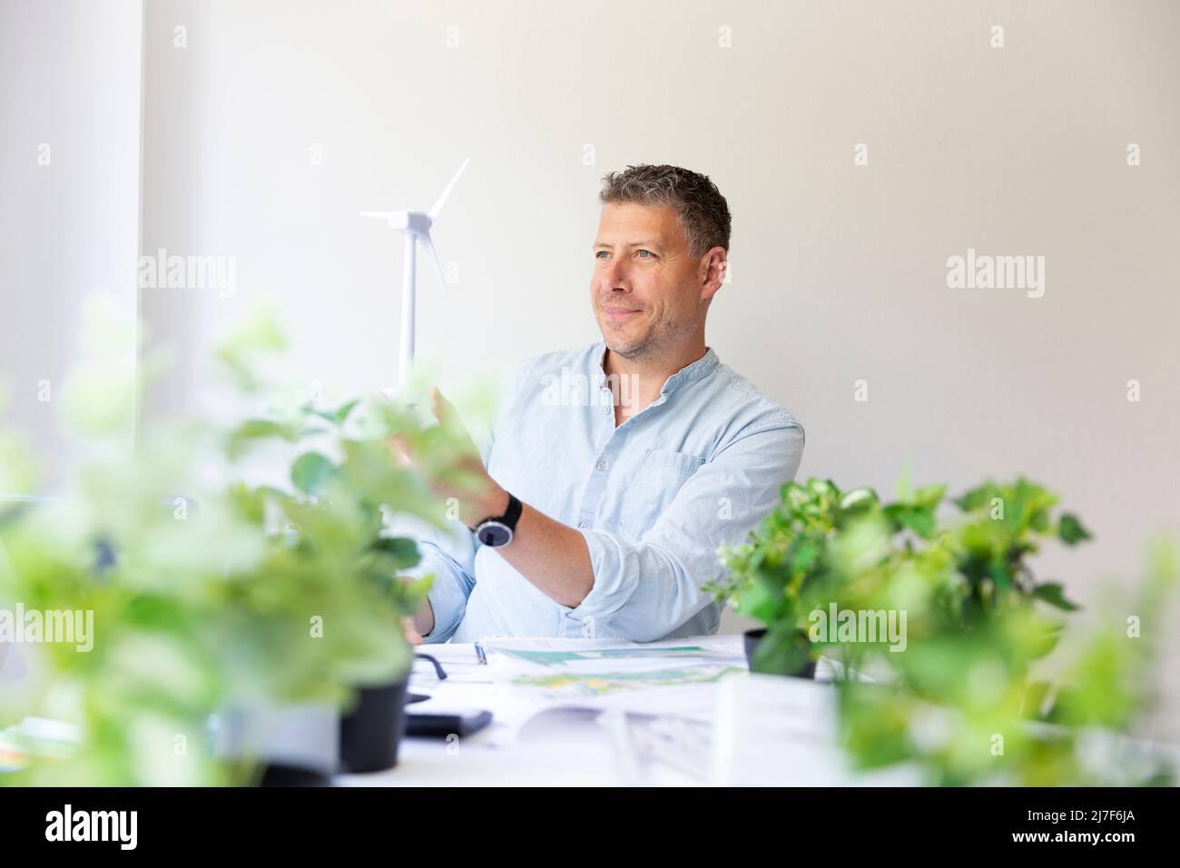 Business portrait of environmental engineer sitting at his work table ...