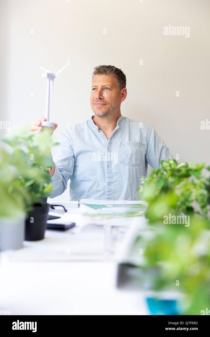 Business portrait of environmental engineer sitting at his work table ...