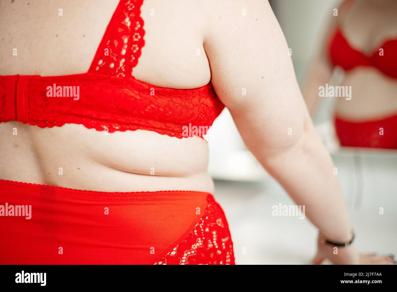 body parts of an overweight woman in beautiful red underwear . selective focusing with a small ...