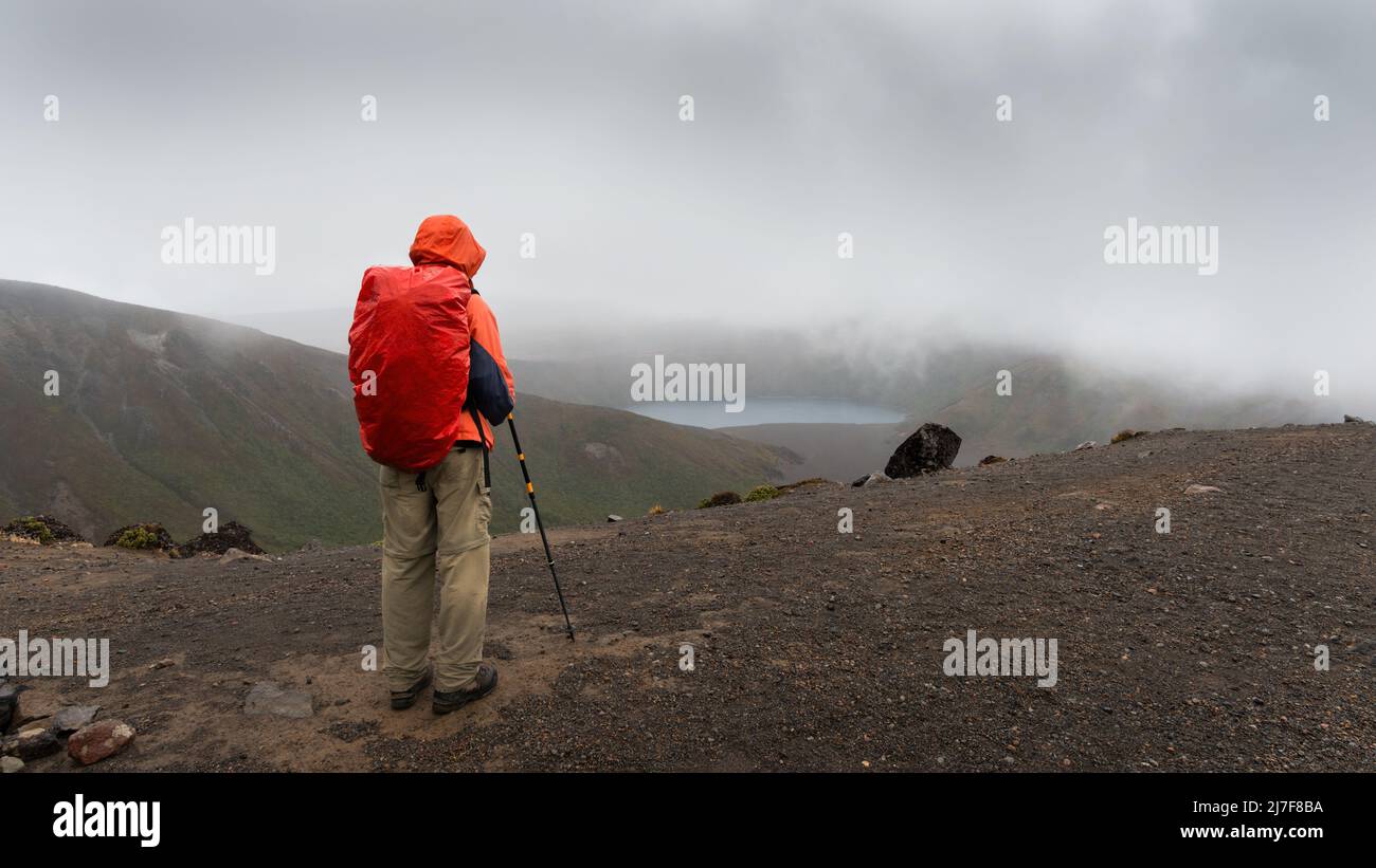 Hiking Tama Lakes track. Man looking at lower Tama lake in the mist ...