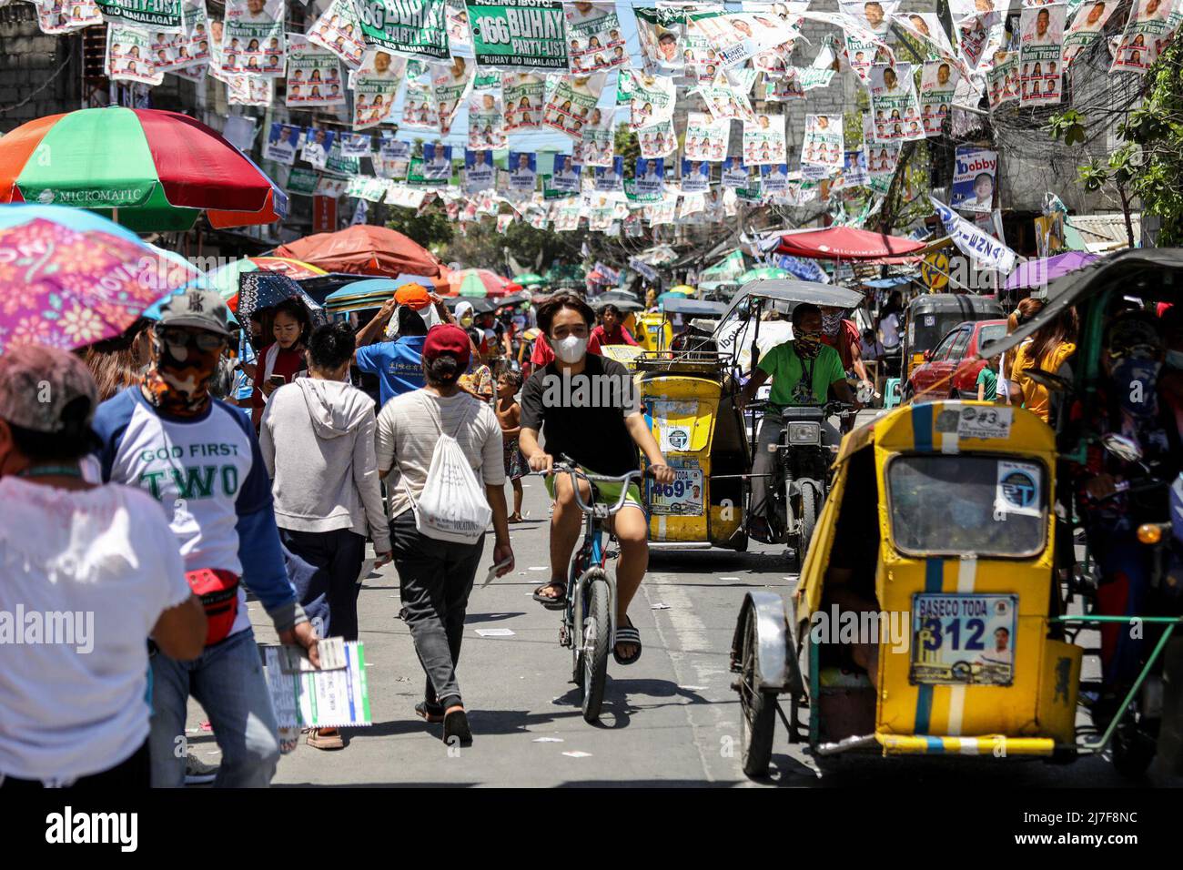 Manila, Philippines. 9th May, 2022. People walk underneath campaign ...