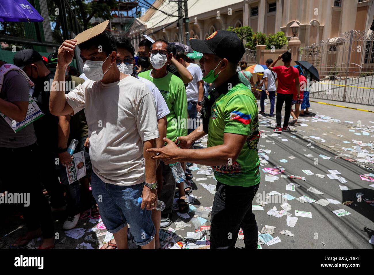 Manila, Philippines. 9th May, 2022. An officer guides people as they ...