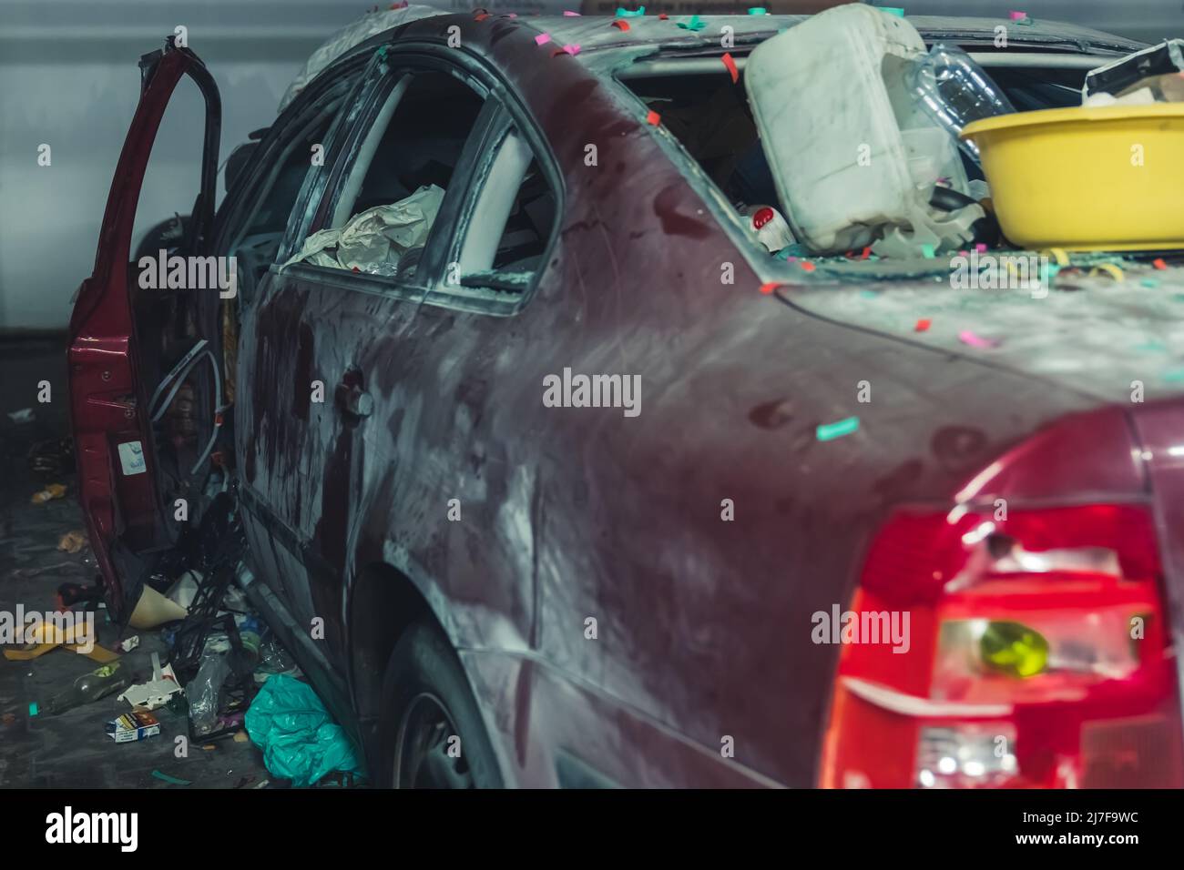 destroyed car with garbage standing in the underground parking lot ...