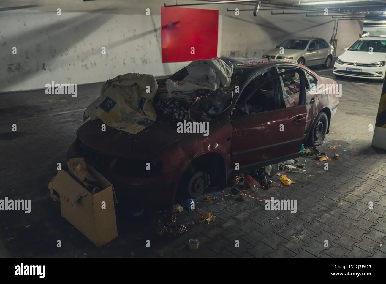 the front side of an abandoned car full of dust, filthy with broken ...