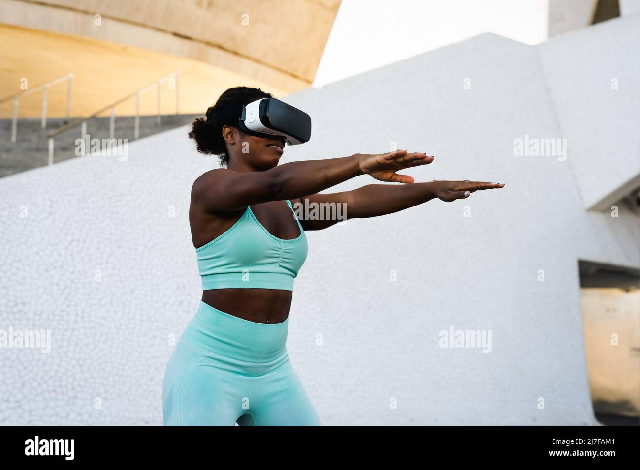 Happy fit African woman using futuristic virtual reality glasses during ...