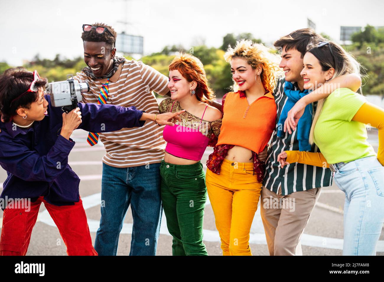 Happy young diverse friends having fun with old vintage video camera ...