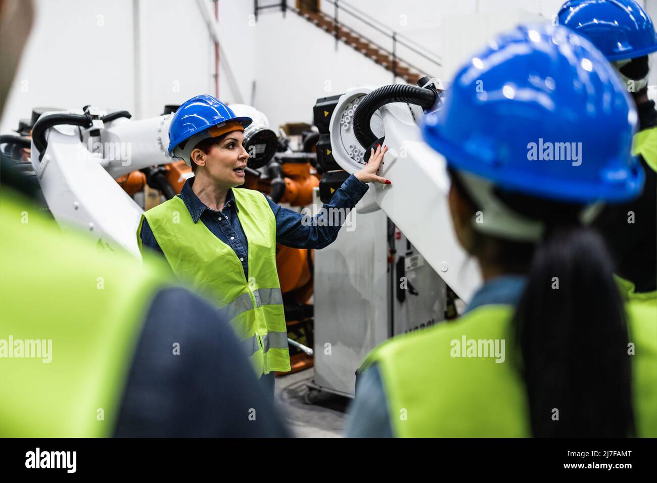 Team of engineers working in robotic factory - Tech industry concept ...