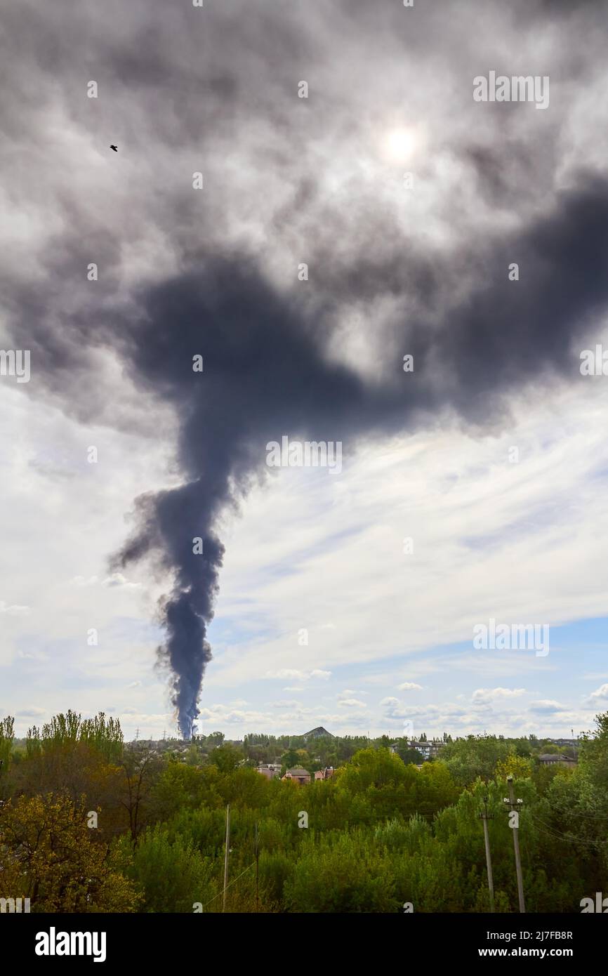 Toxic black cloud of fumes and smoke coming from burning tank with fuel ...