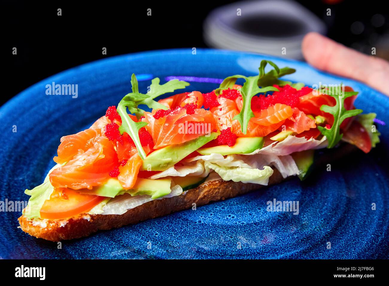 Bruschetta with salmon, avocado and flying fish caviar Stock Photo - Alamy