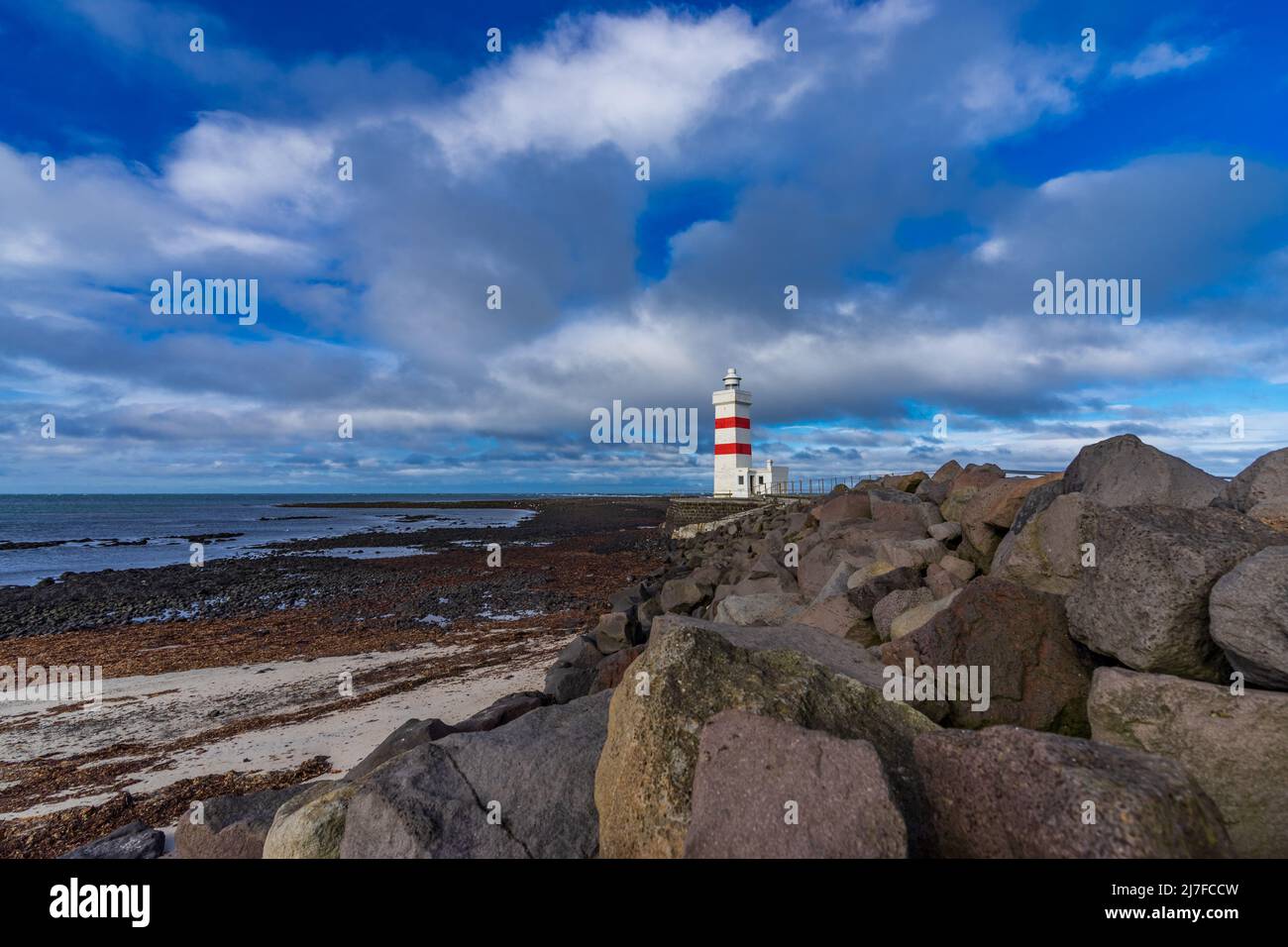 Lighthouse with red stripes wide angle with cloudscape Stock Photo - Alamy