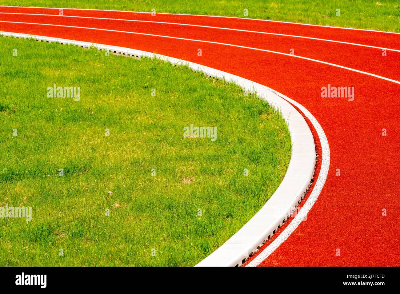 Empty artificial running track with curved white lines Stock Photo - Alamy