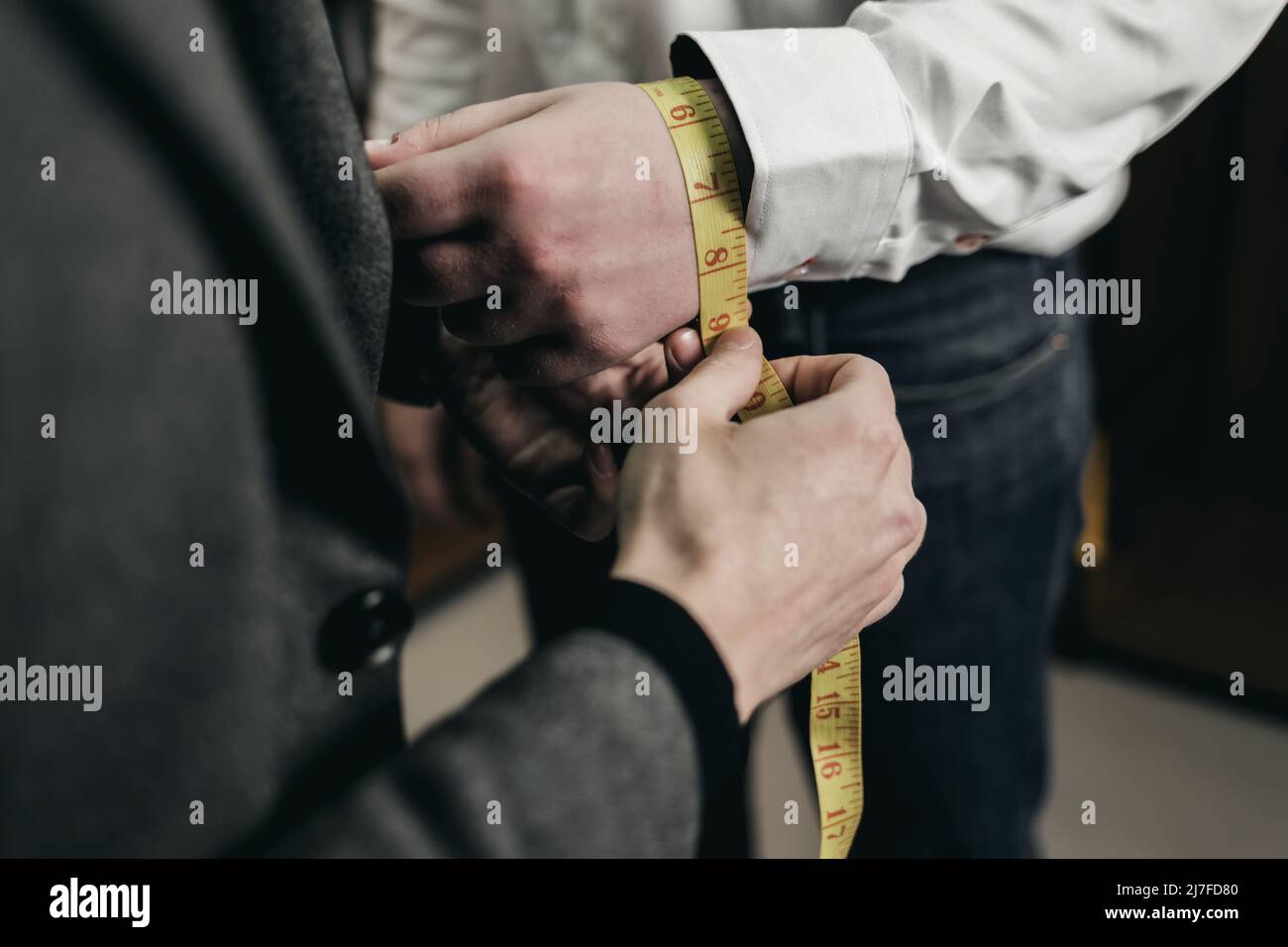 Tailor taking measurements for client. individual tailoring Stock Photo ...