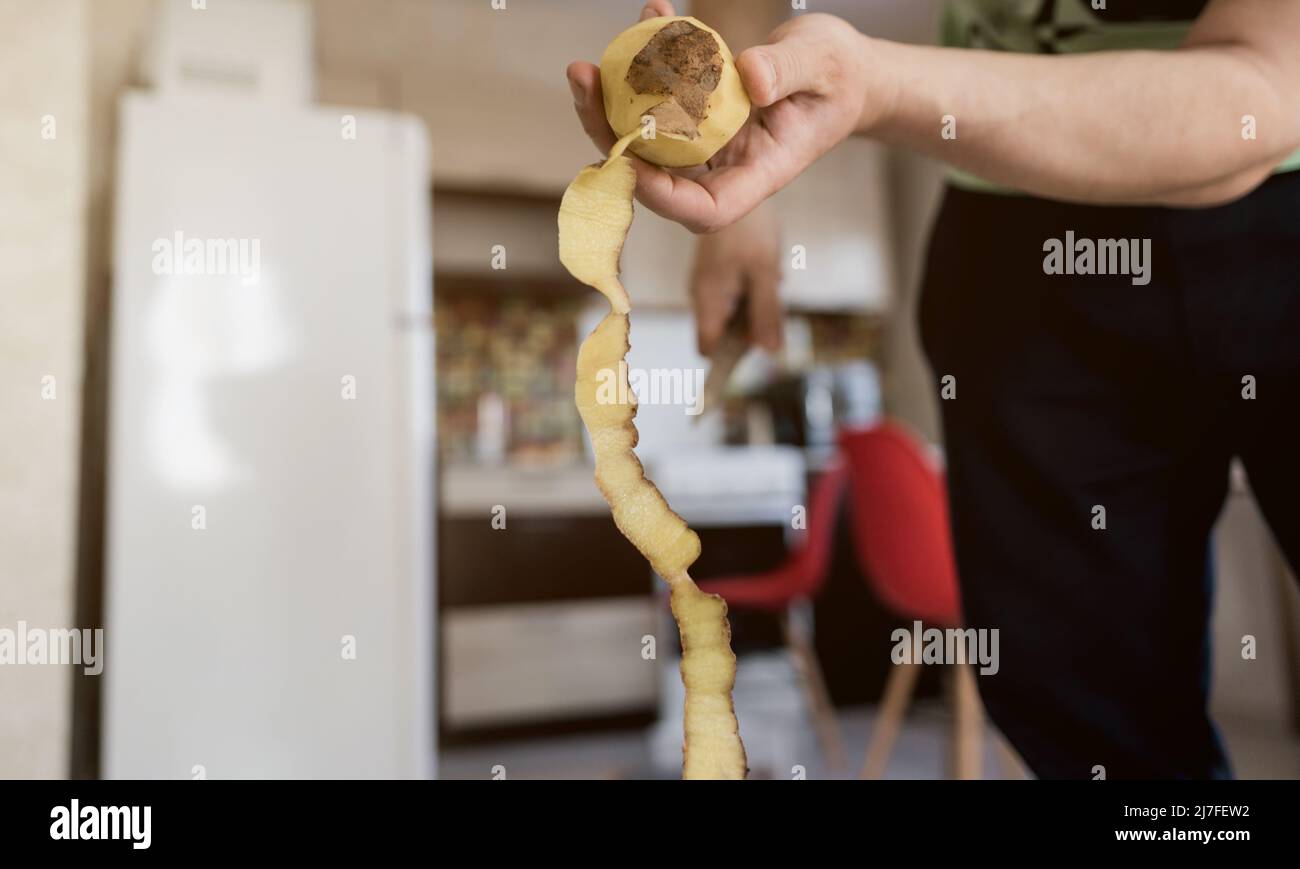 Man peels raw potatoes potato hi-res stock photography and images - Alamy