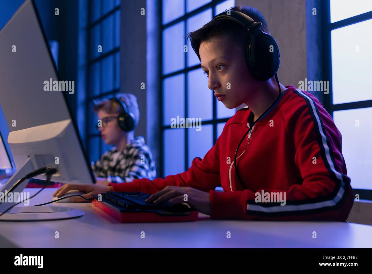 Young gamer boys with headphones playing computer video game Stock ...