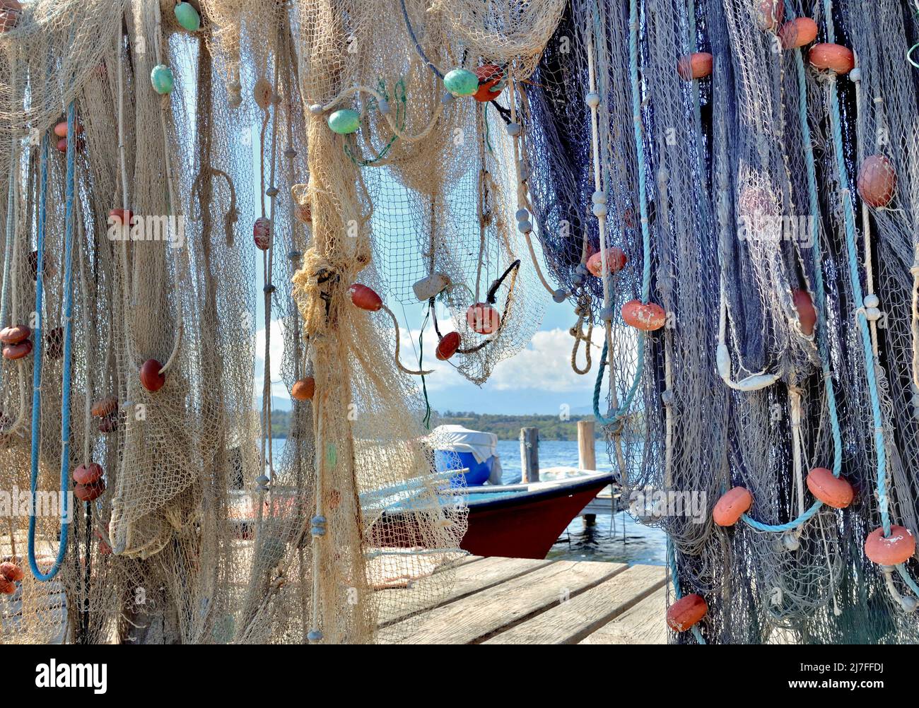 hanging fishing nets stowed on a pontoon in front of a boat Stock Photo ...