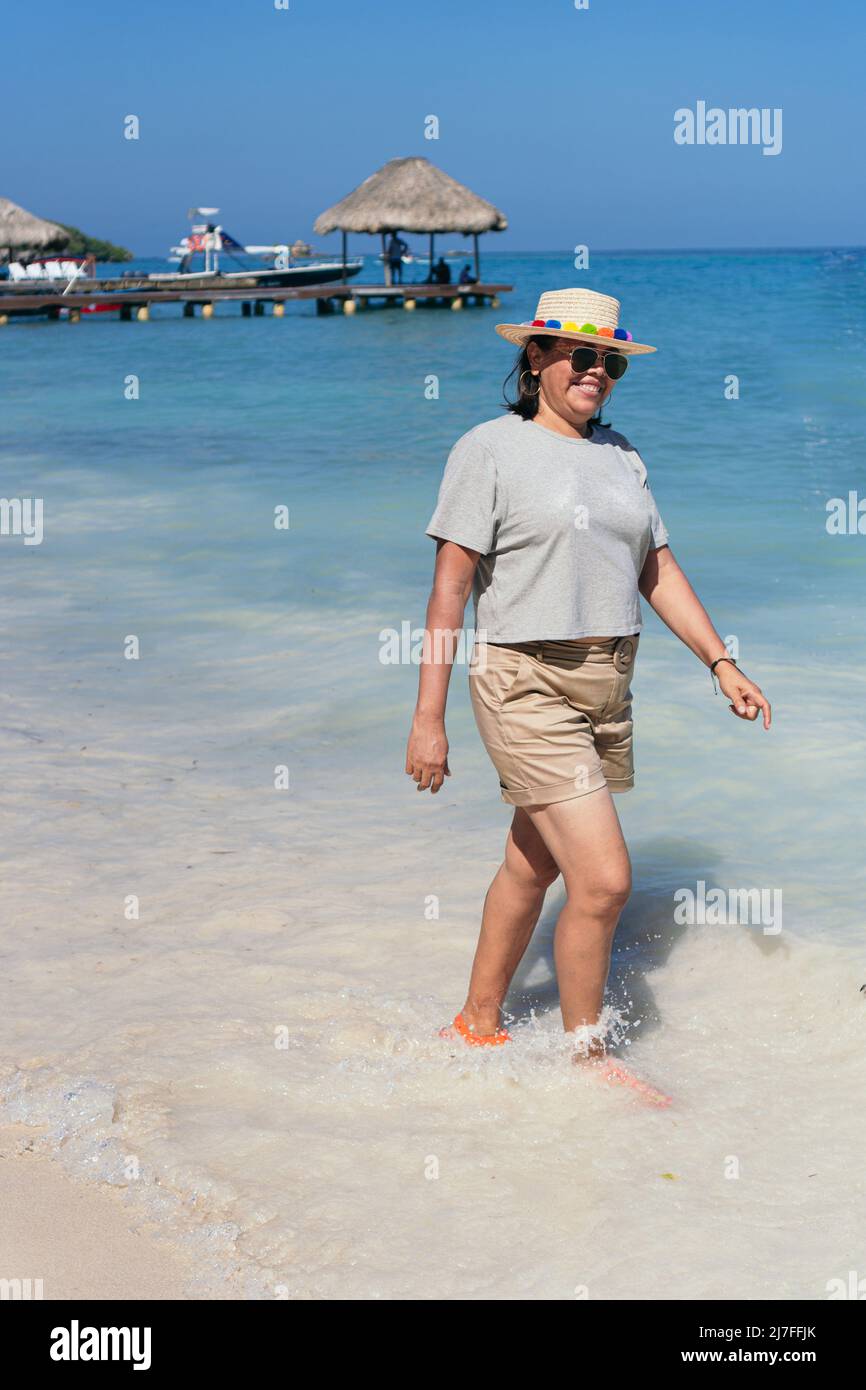 Mature woman walking on beach Stock Photo - Alamy