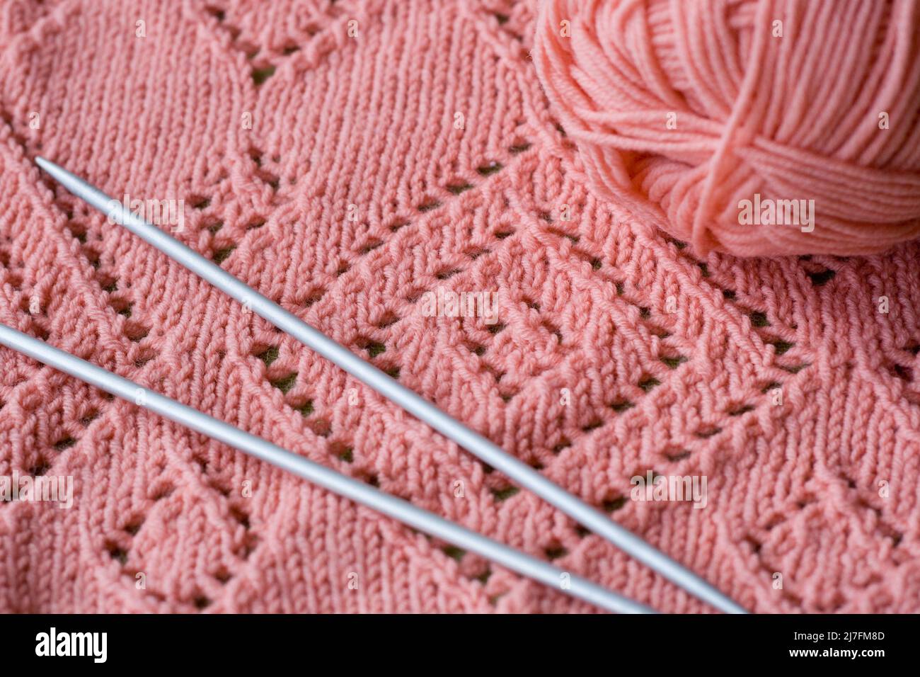 Knitted element pink skein of yarn and knitting needles Stock Photo - Alamy