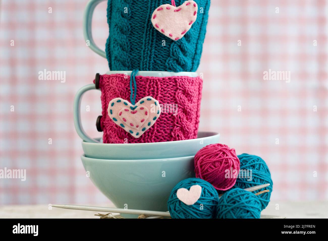 Bright balls of yarn in blue plates and handmade from felt heart Stock ...