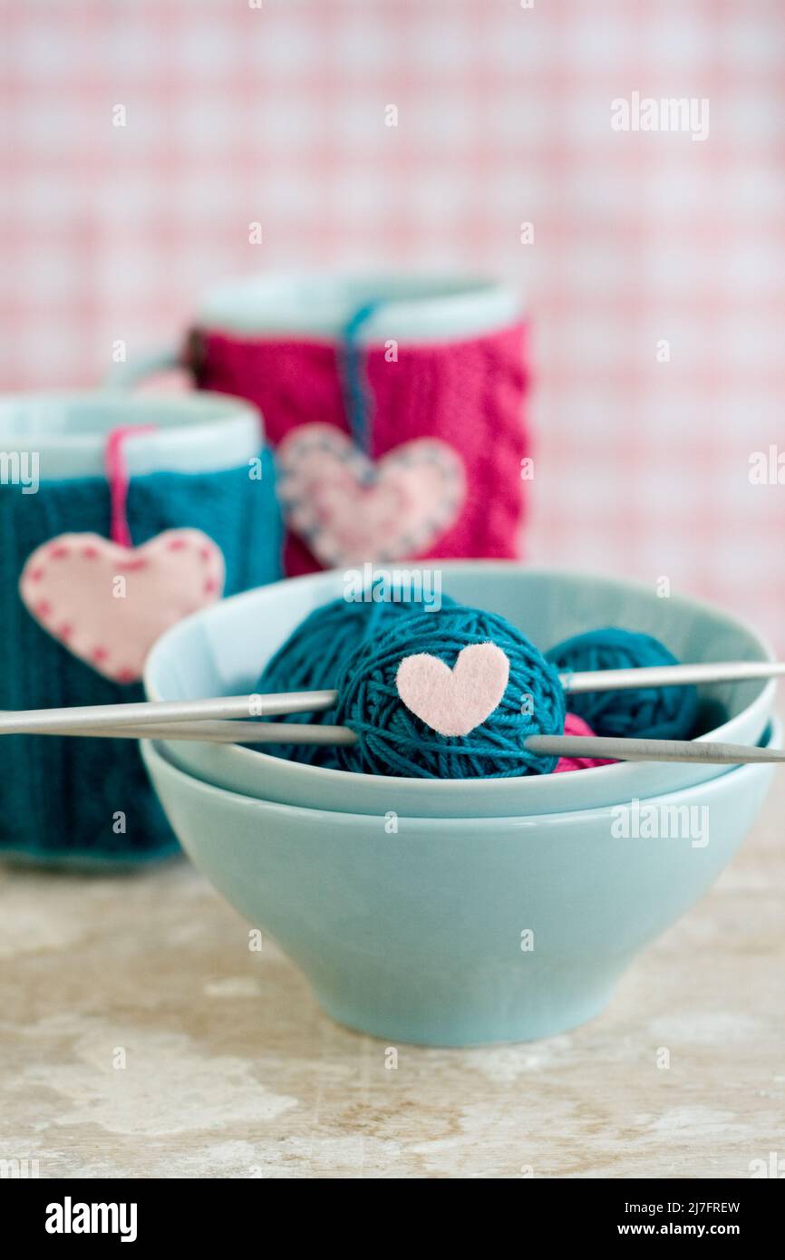 Bright balls of yarn in blue plates and handmade from felt heart Stock ...