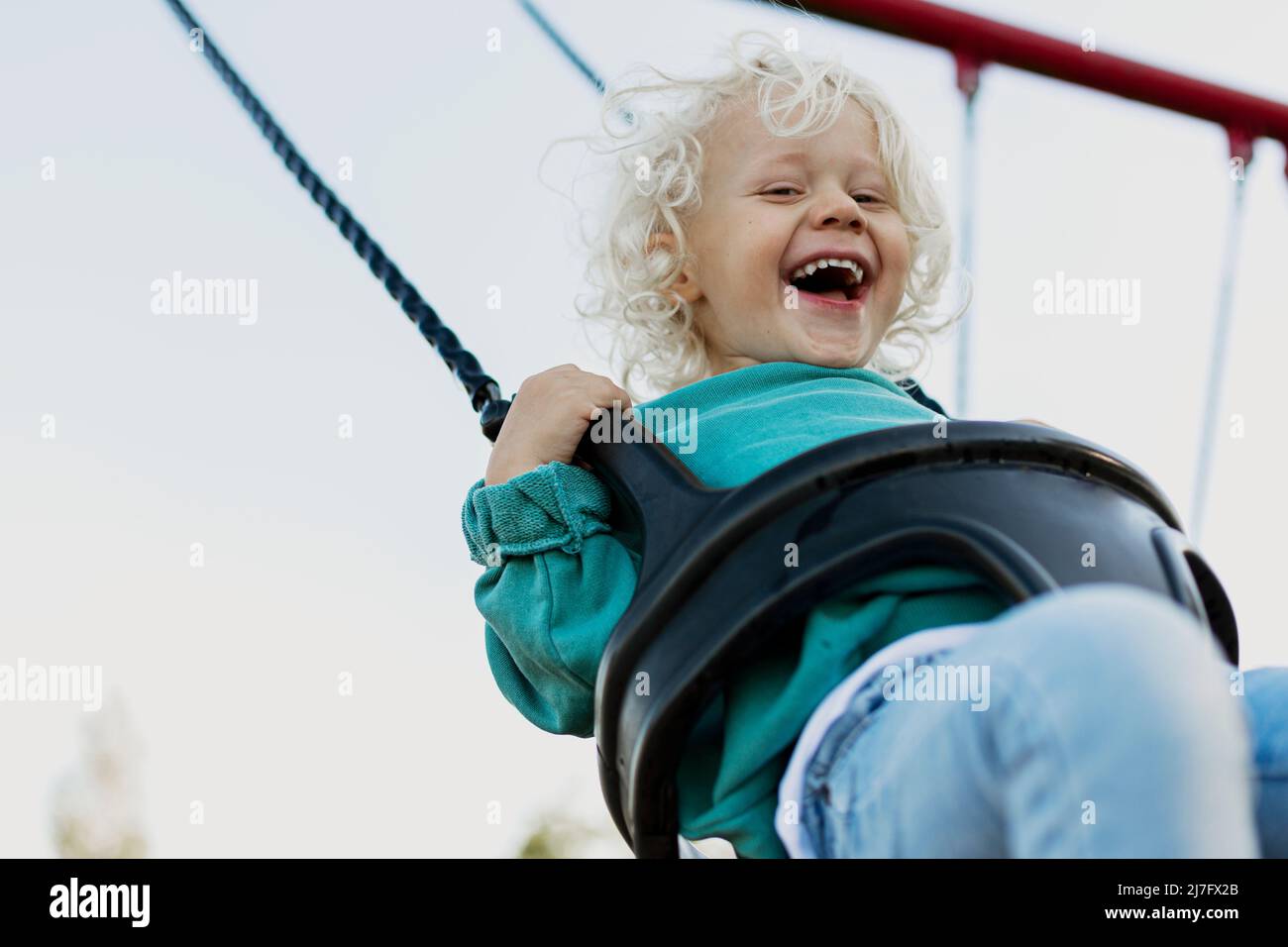 Happy child swinging Stock Photo - Alamy