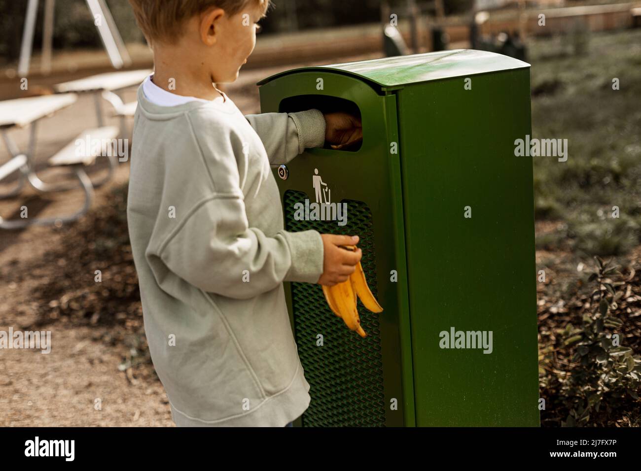 Boy throwing rubbish into bin Stock Photo - Alamy