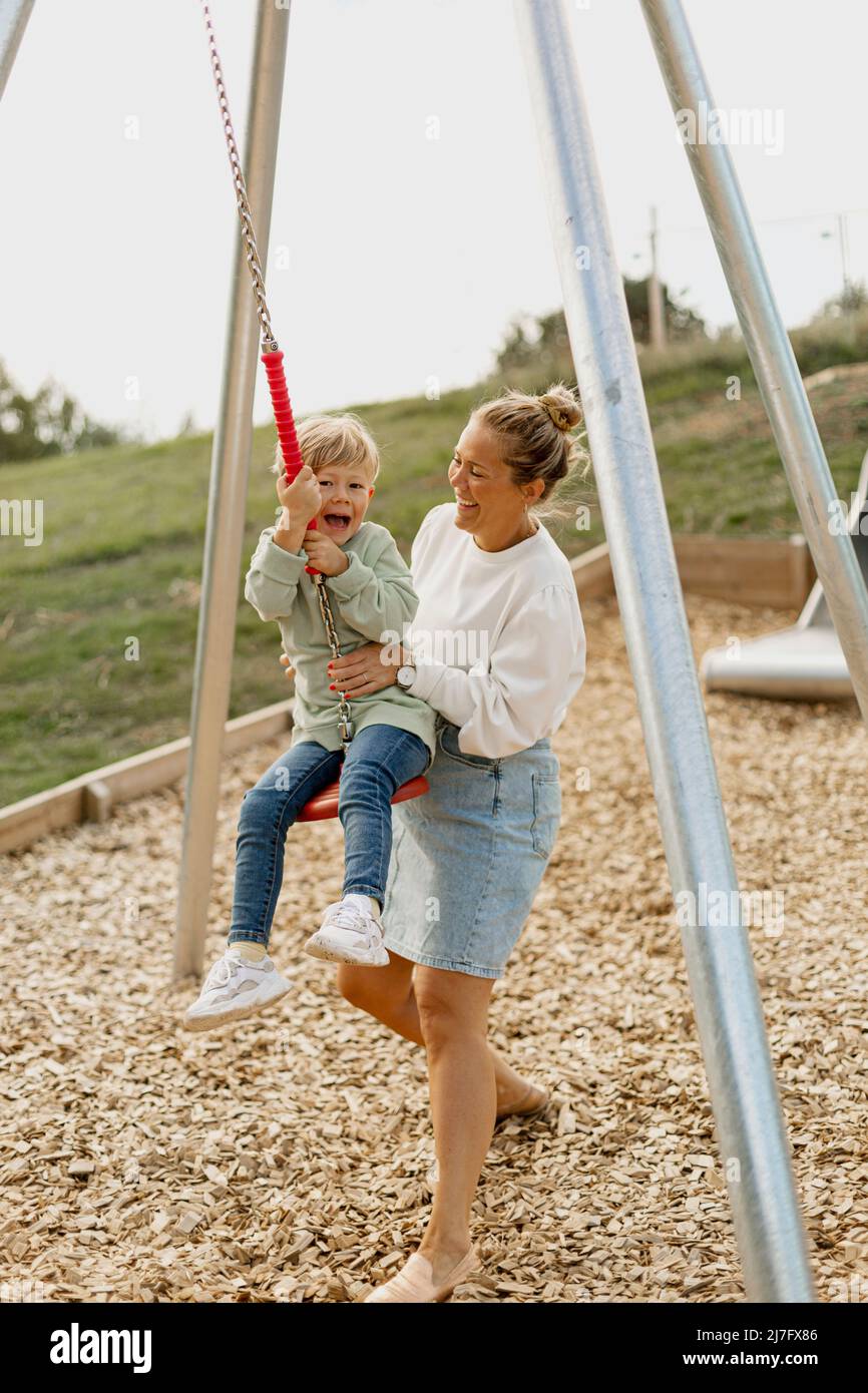 Mother son playground swing hi-res stock photography and images - Alamy