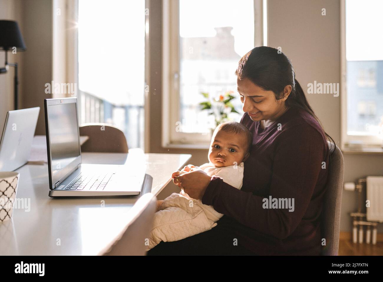Mother with baby working from home Stock Photo - Alamy