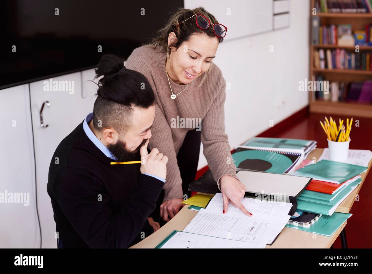 Teachers talking in classroom Stock Photo - Alamy