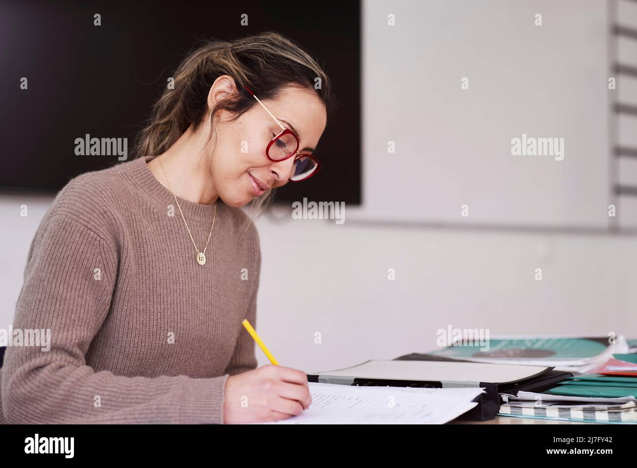 Female teacher working in classroom Stock Photo - Alamy
