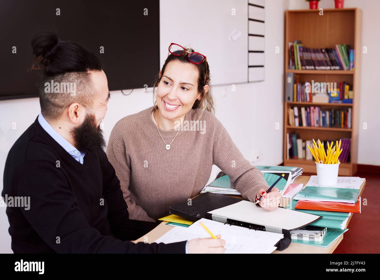 Teachers talking in classroom Stock Photo - Alamy