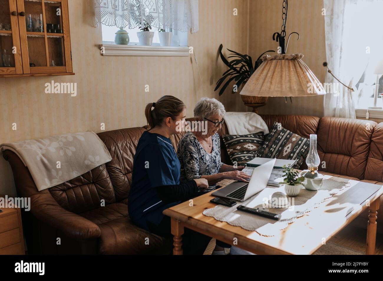 Home caretaker helping senior woman with bills Stock Photo - Alamy