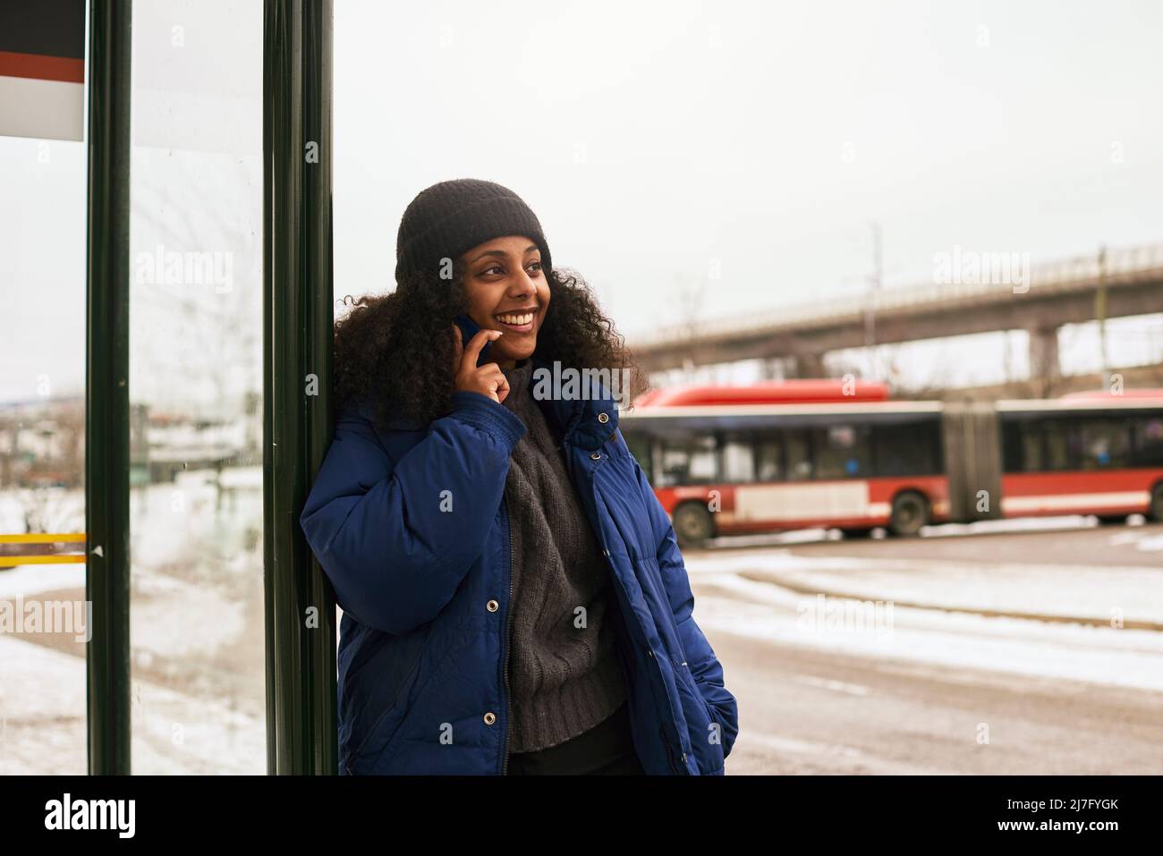 Woman talking via cell phone at bus stop Stock Photo - Alamy