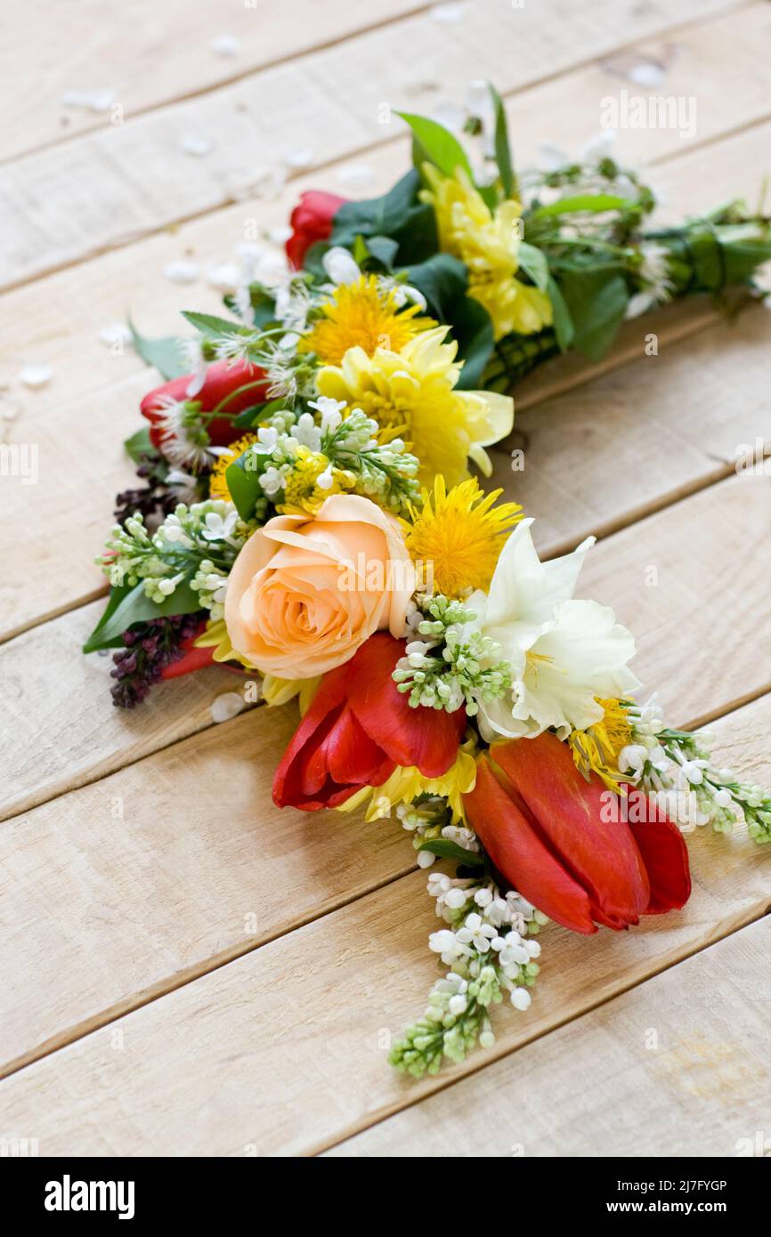Bouquet of colorful spring flowers lying on the unpainted wooden ...
