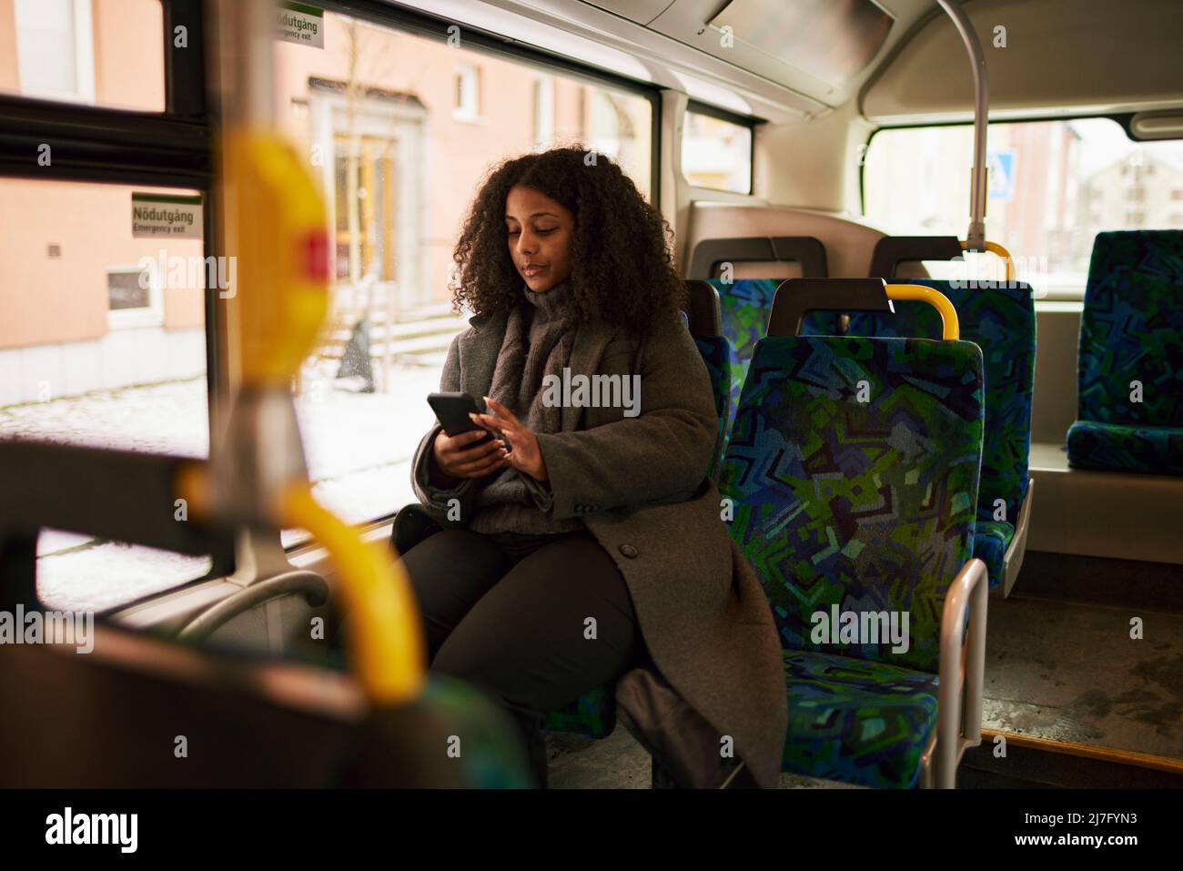 Woman in bus using cell phone Stock Photo - Alamy