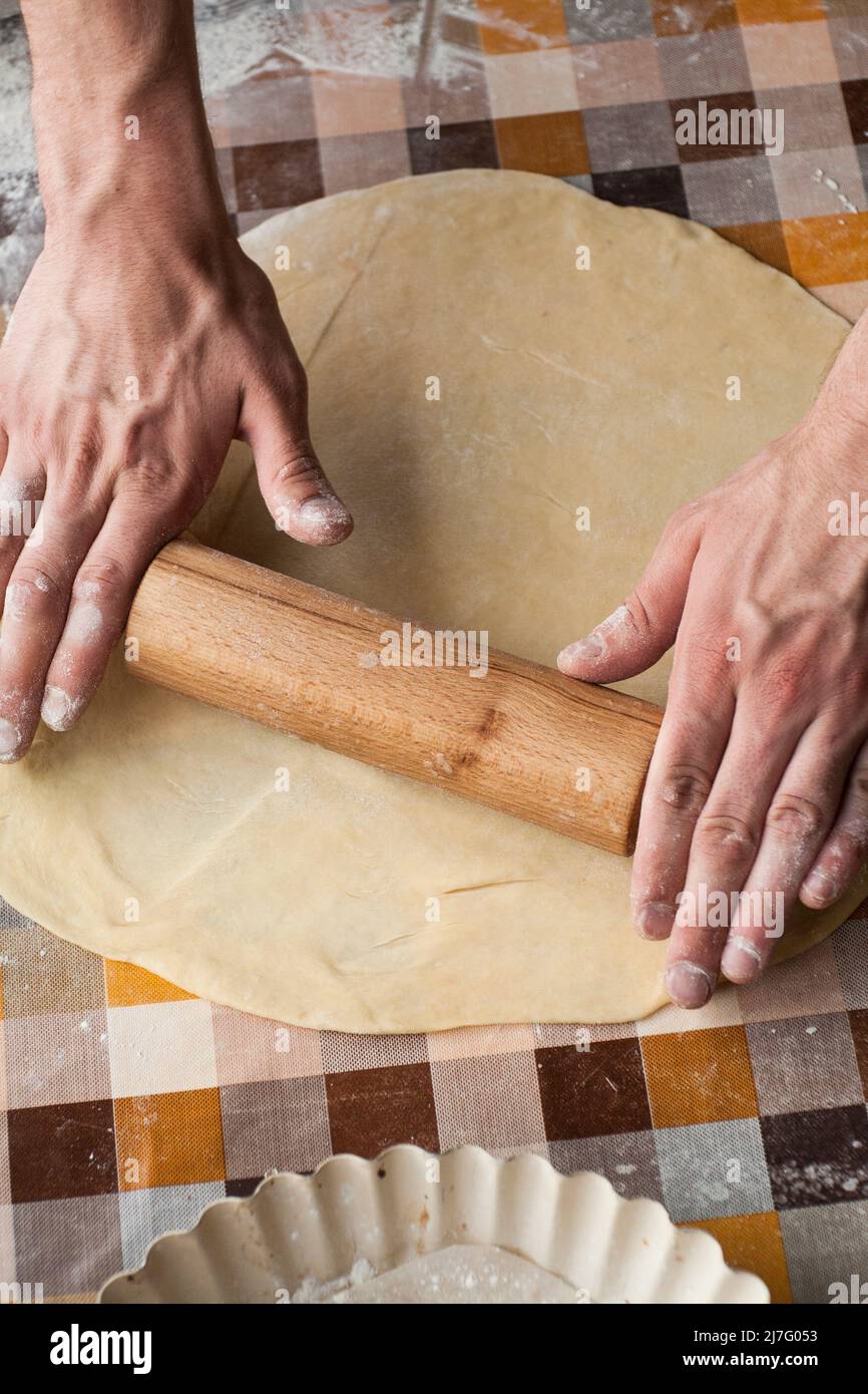 Cooking and home concept - close up of male hands kneading dough on a ...
