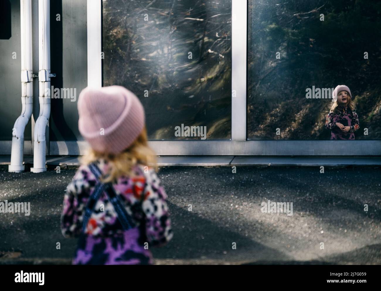 Girl reflecting in building wall Stock Photo - Alamy