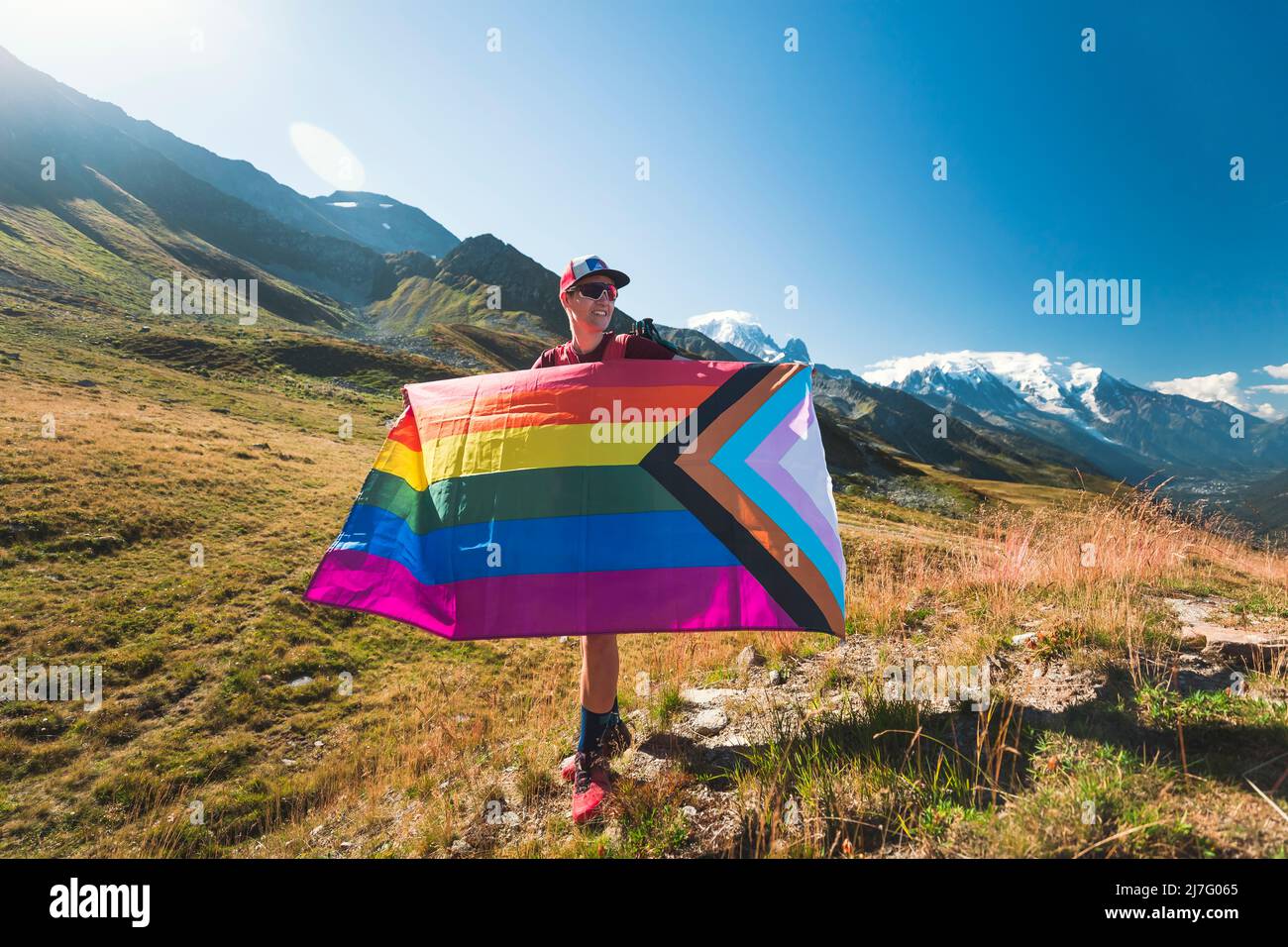 Man holding LGBTIQ Community flag in mountains Stock Photo - Alamy