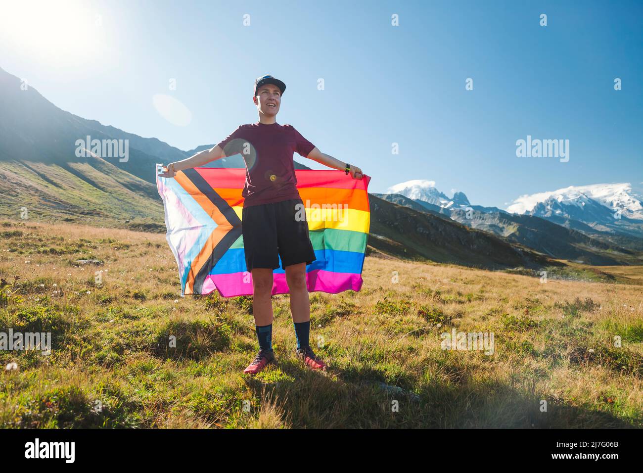 Man holding LGBTIQ Community flag in mountains Stock Photo - Alamy